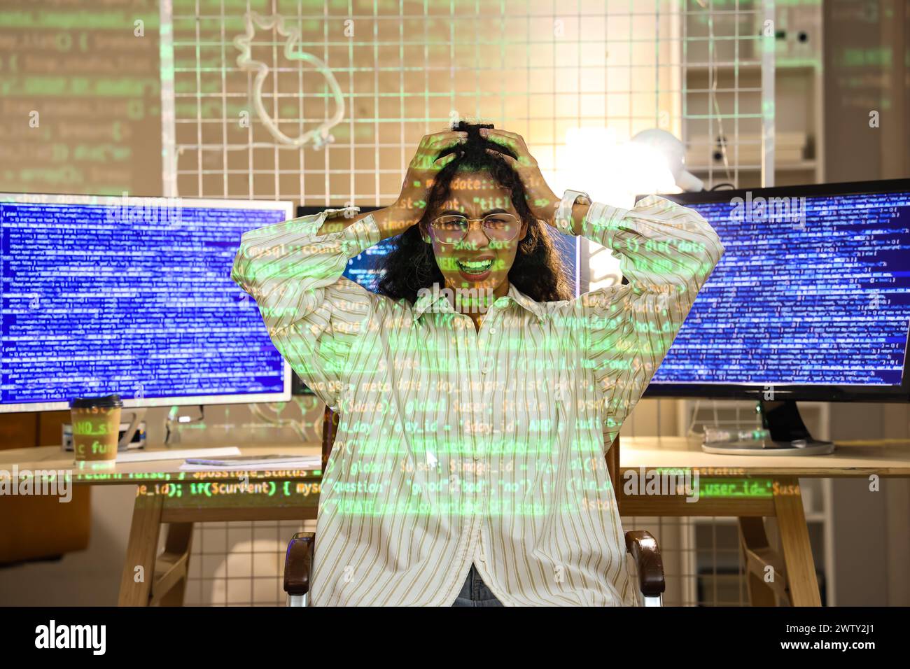 Stressed female African-American programmer with projection of code in ...