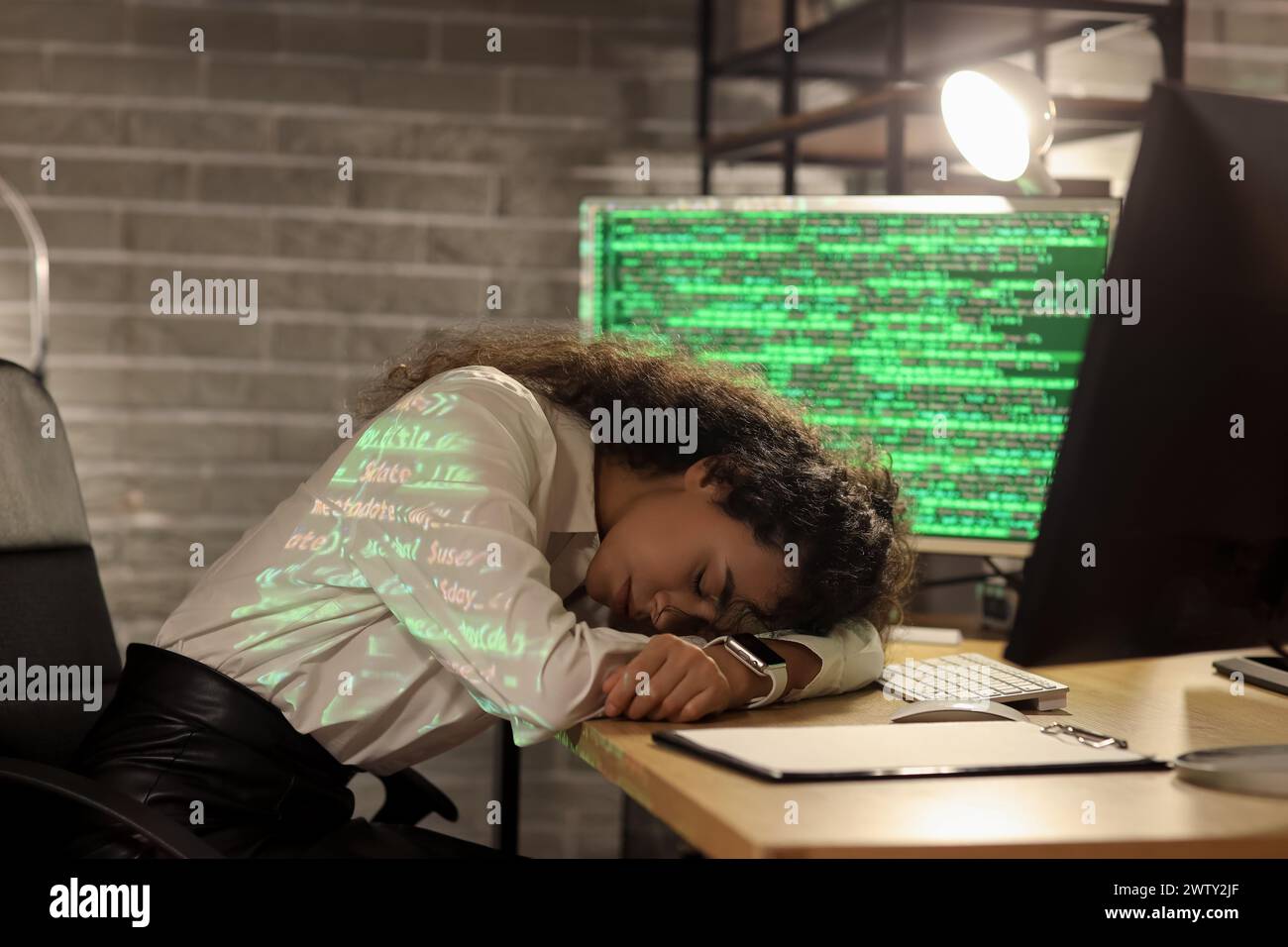 Female African-American programmer sleeping in office at night Stock ...