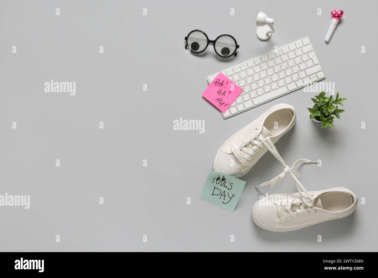 Shoes with tied laces, computer keyboard and funny glasses on white ...