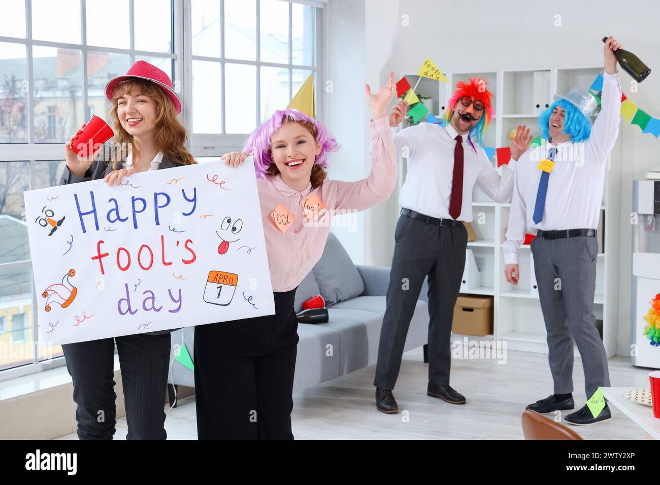 Business colleagues with poster celebrating April Fools' Day at office ...