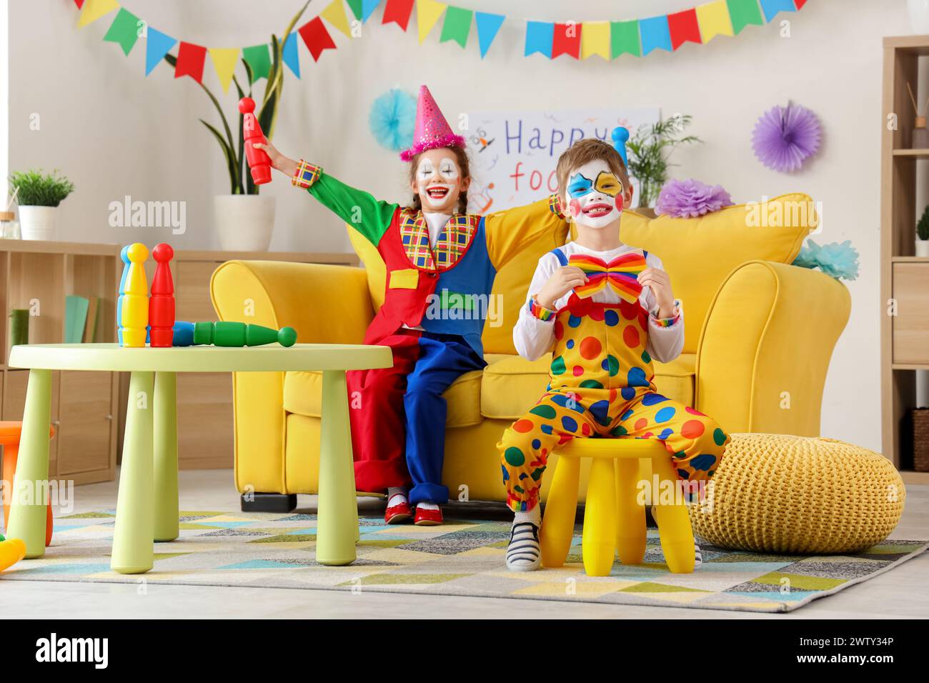 Funny little children in clown costumes at home. April Fools' Day ...