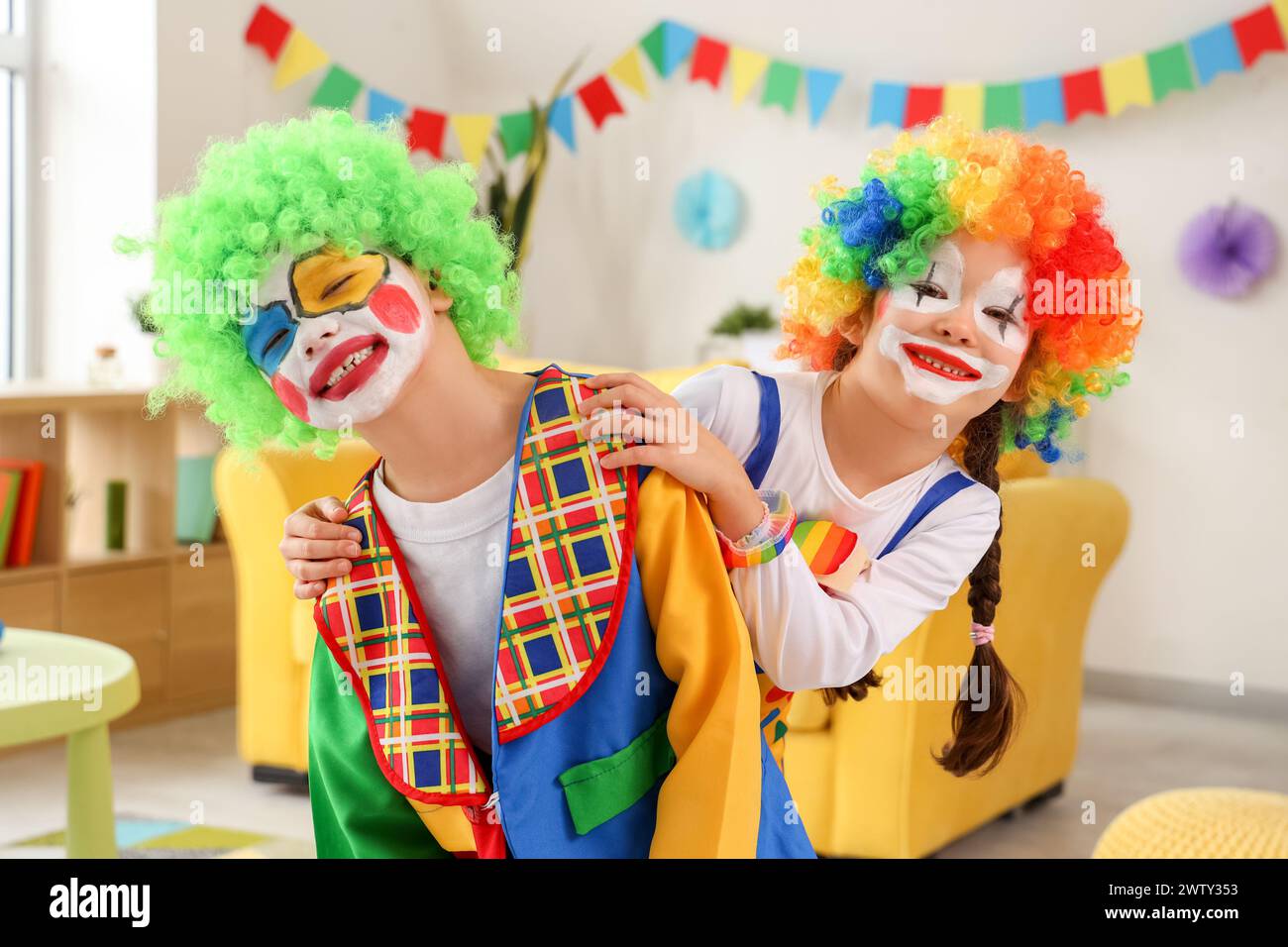 Funny little children in clown costumes at home. April Fools' Day ...