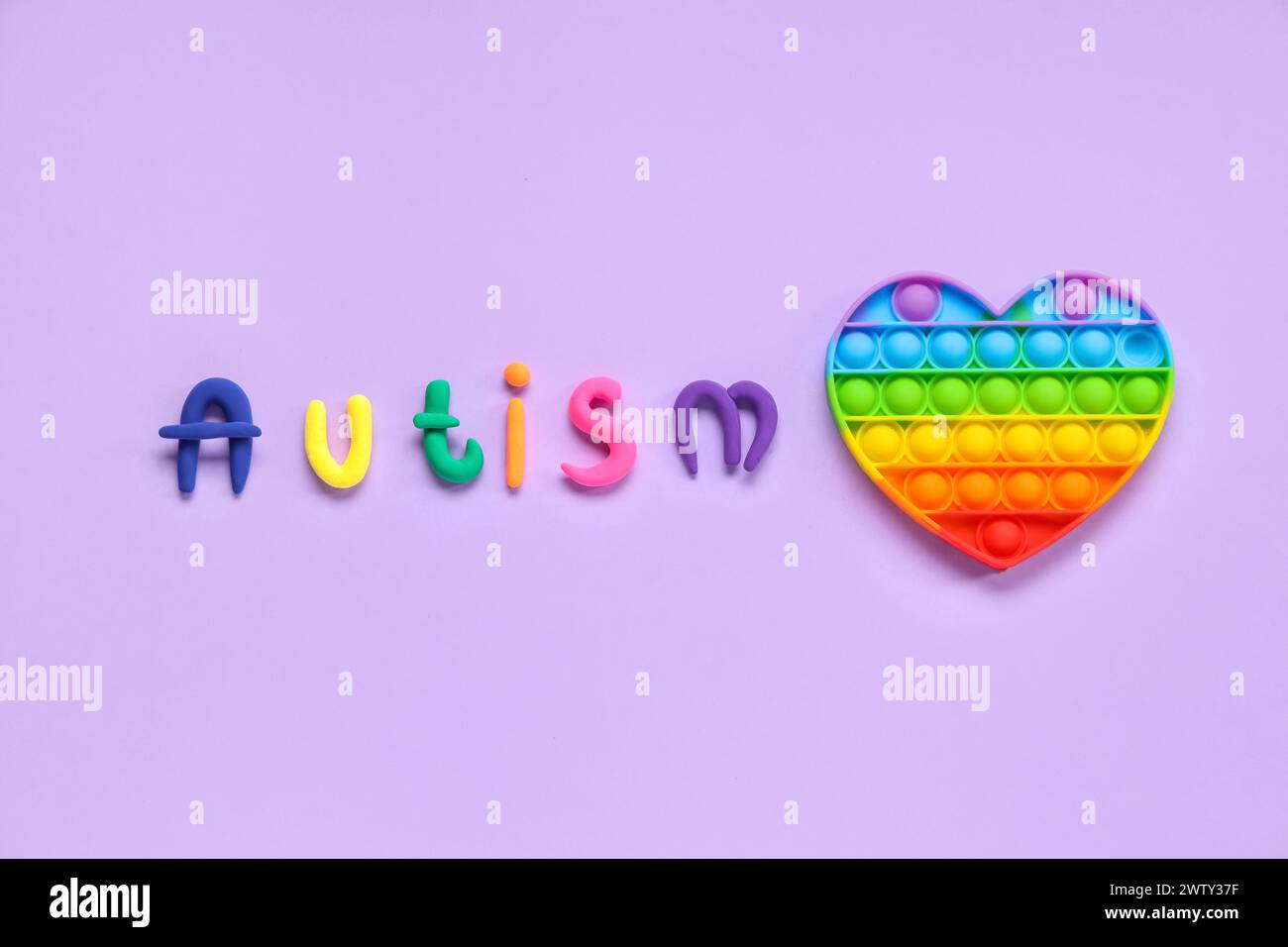 Word AUTISM with colorful pop it on lilac background Stock Photo - Alamy
