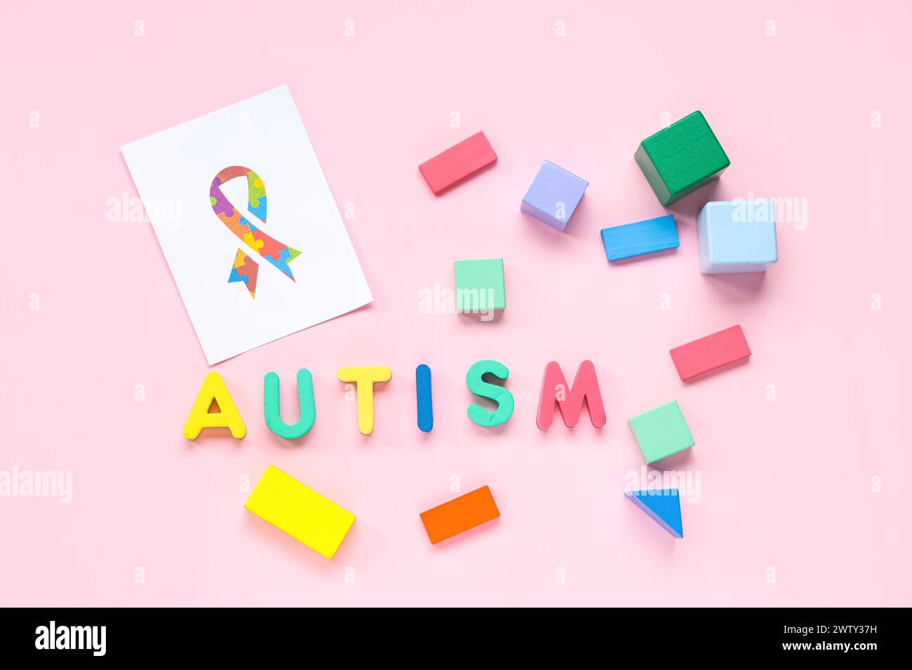 Word AUTISM, children toys and awareness ribbon on pink background ...