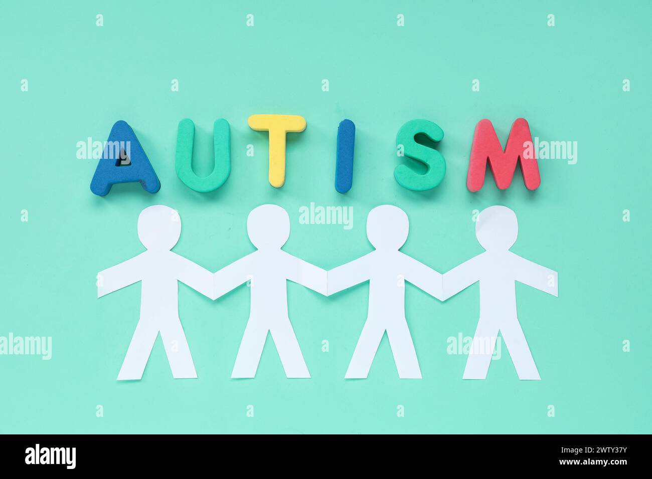 Word AUTISM, paper people and awareness ribbon on pink background ...