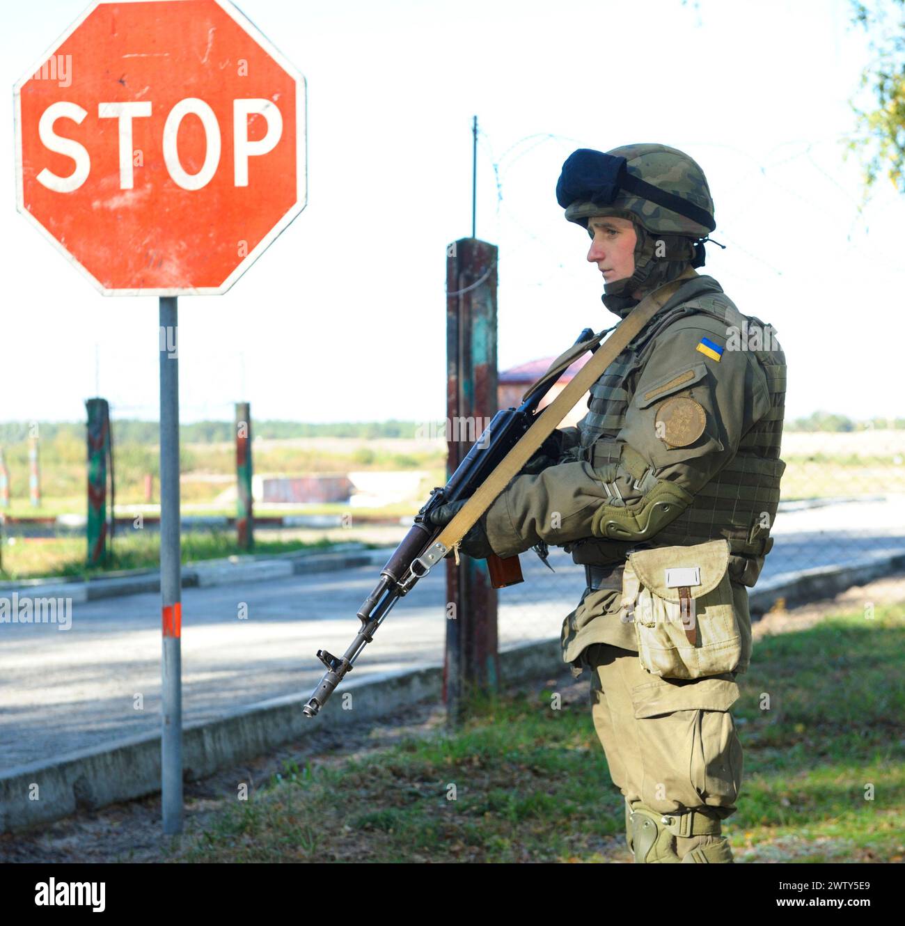 Fully equipped soldiers guarding the checkpoint in front of the sign ...