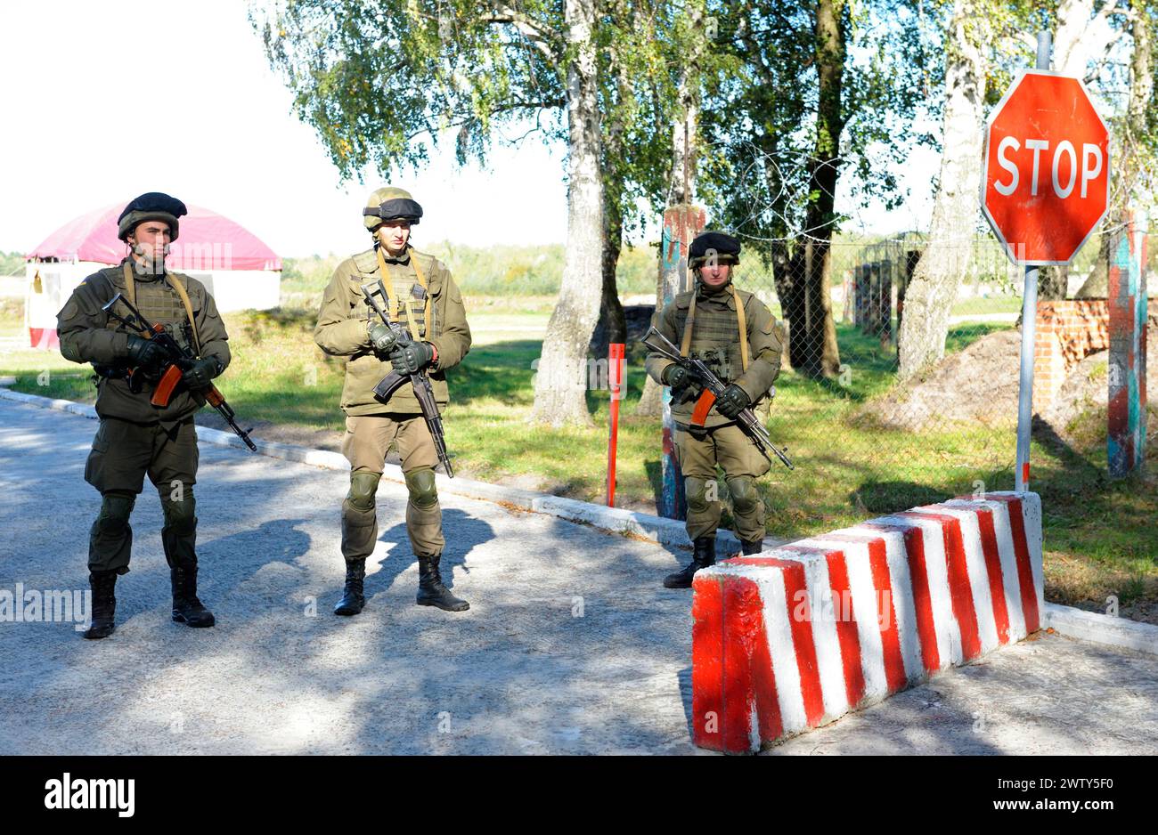 Fully equipped soldiers guarding the checkpoint in front of the sign ...