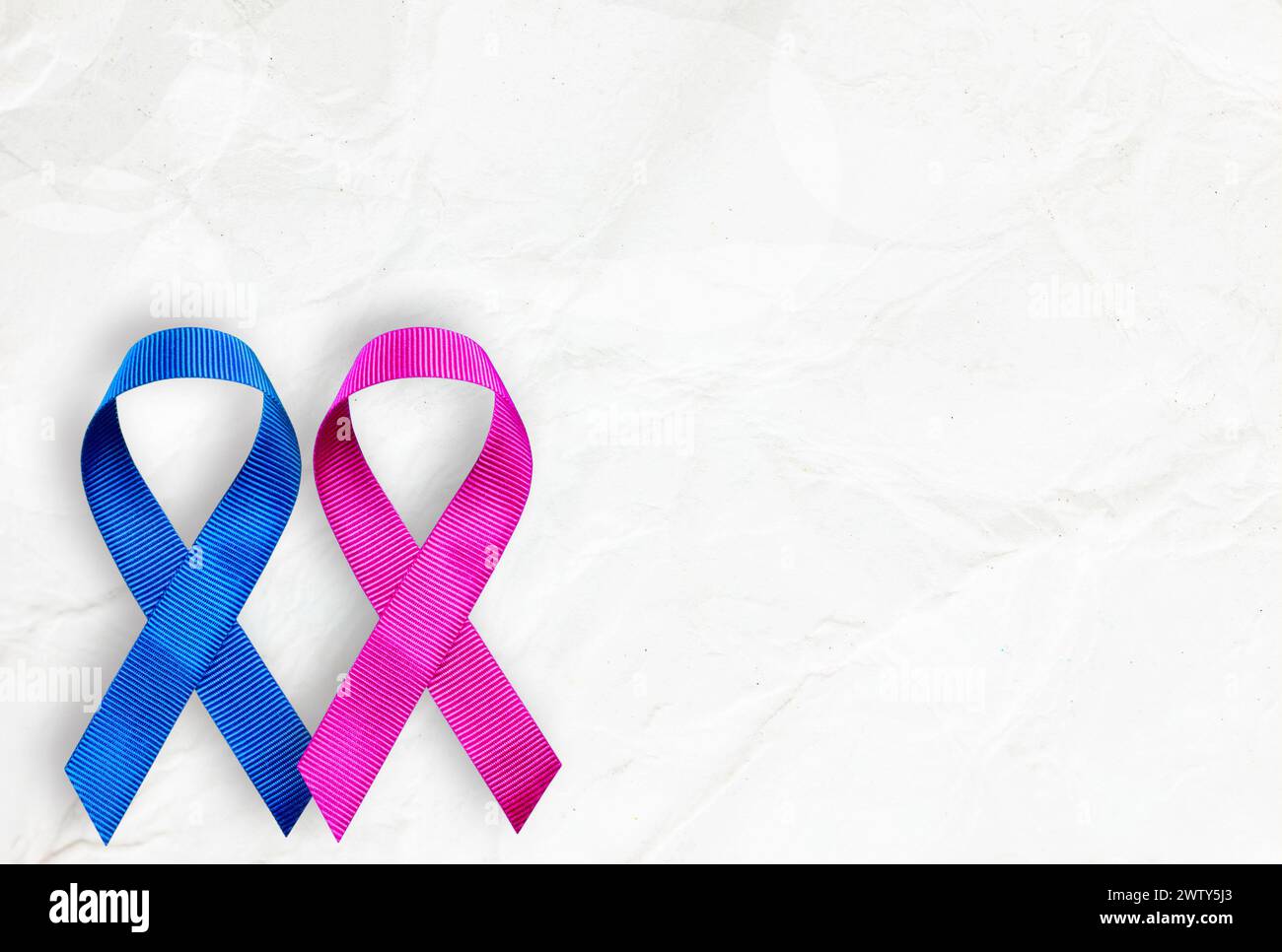 Pink and blue ribbons on white paper background Stock Photo - Alamy