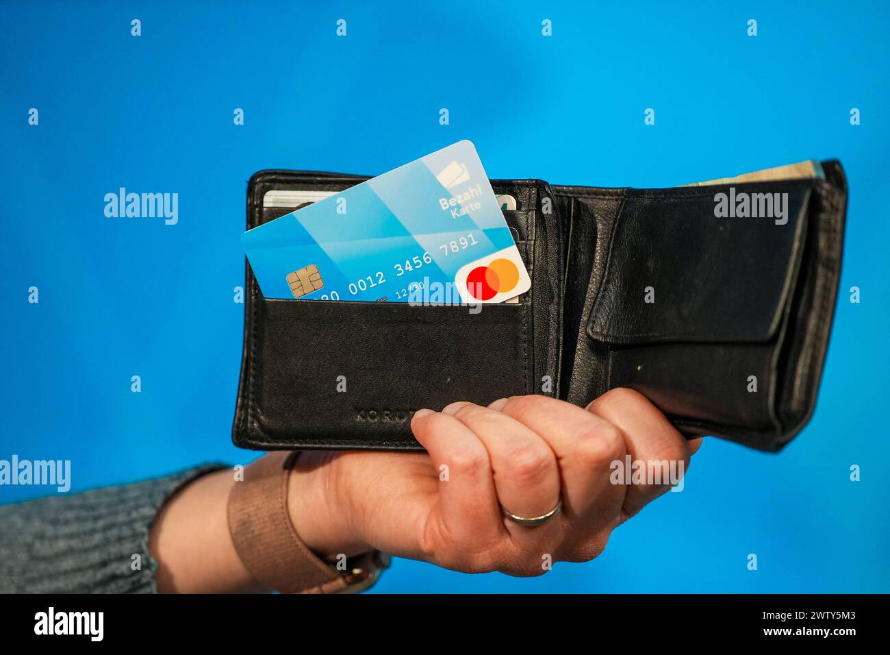 Munich, Bavaria, Germany - March 20, 2024: A hand holds a wallet with ...