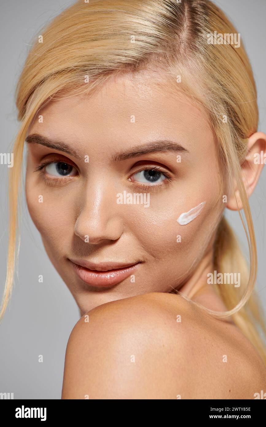 alluring girl face with glowing skin and lotion on her cheek looking ...
