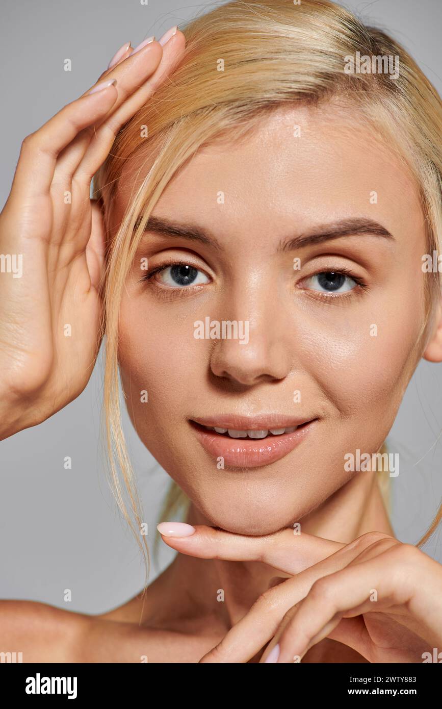 20s girl with gray eyes and healthy skin frames her face with her hands ...