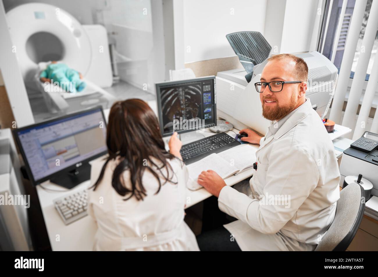 Medical computed tomography or MRI scanner. Portrait of doctor sitting ...