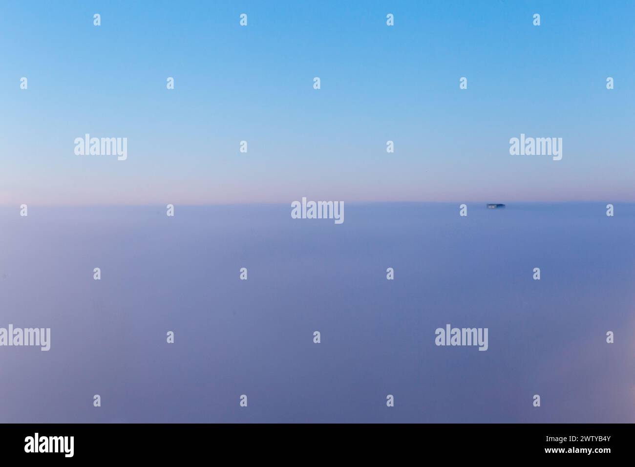 Sunrise in the city, foggy morning, thick low fog and bright blue sky ...