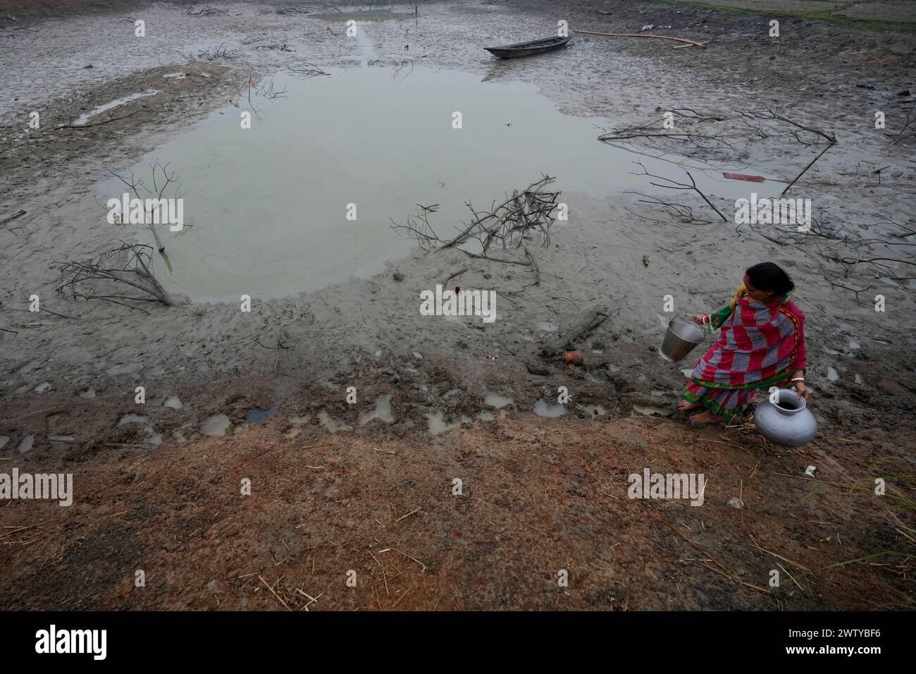 A woman walks to collect drinking water on the outskirts of Guwahati ...