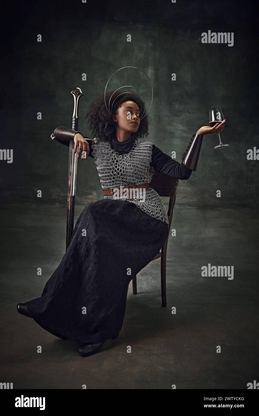 Young elegant African girl, medieval warrior in chainmail armor sitting ...