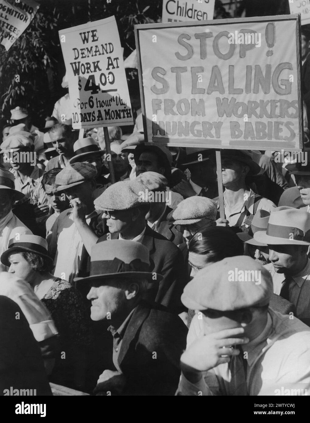 A crowd of men and women protest for jobs, fair wages and working ...