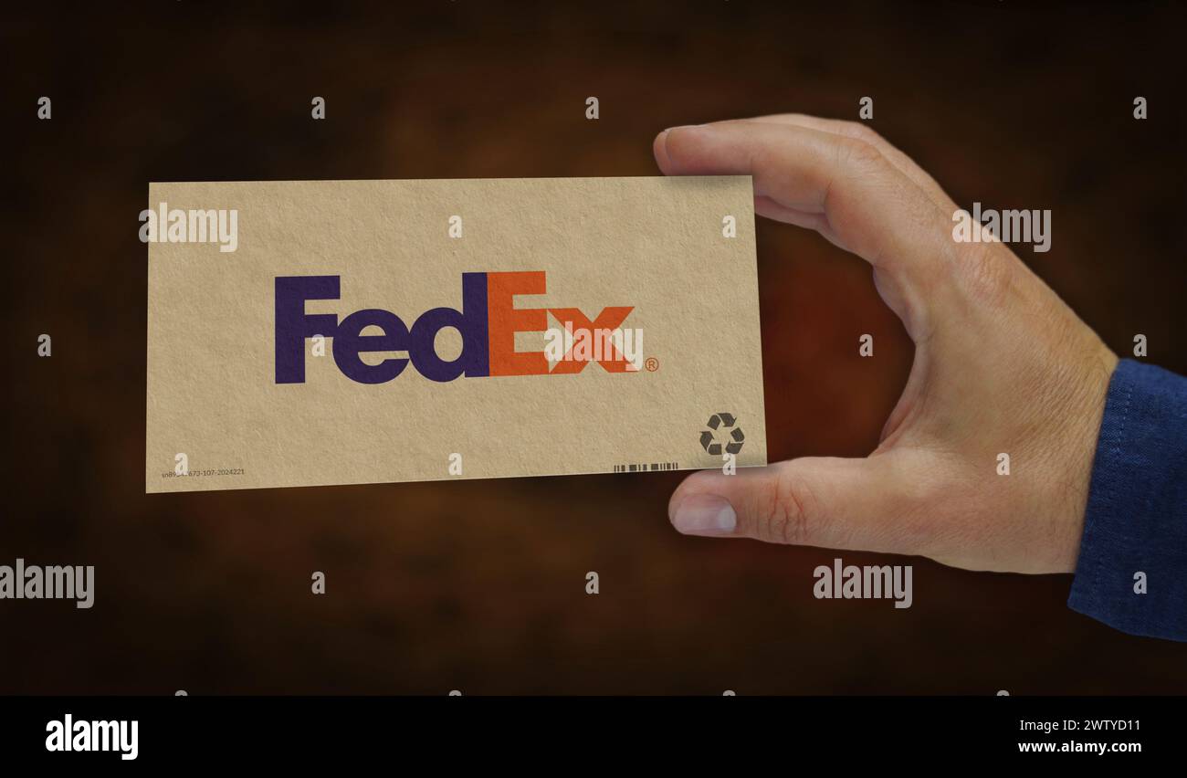Poznan, Poland, March 12, 2024: Fedex delivery box in hand. Federal express shipment company ...