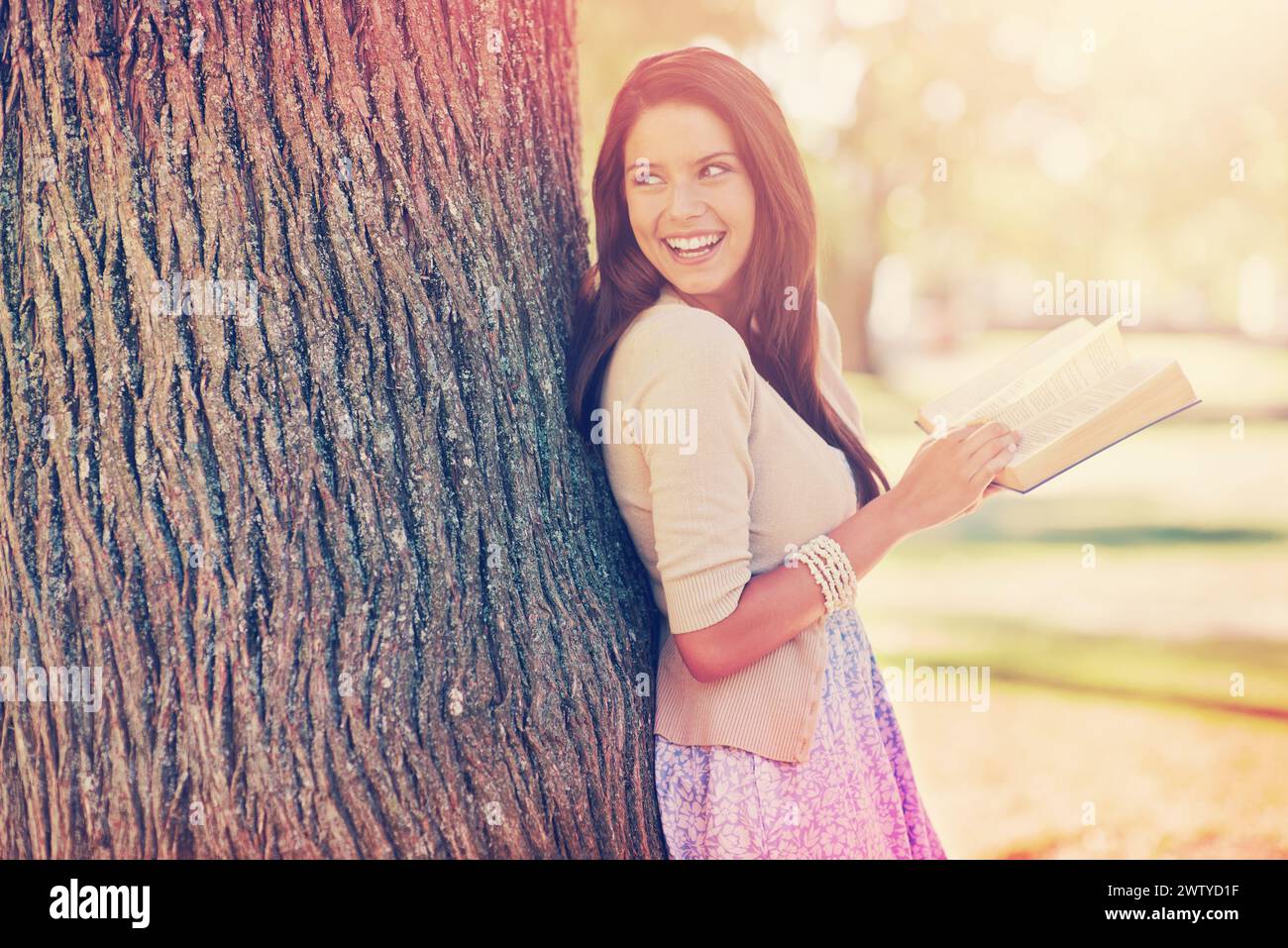 Tree trunk, portrait and woman with smile for novel, book and fiction ...