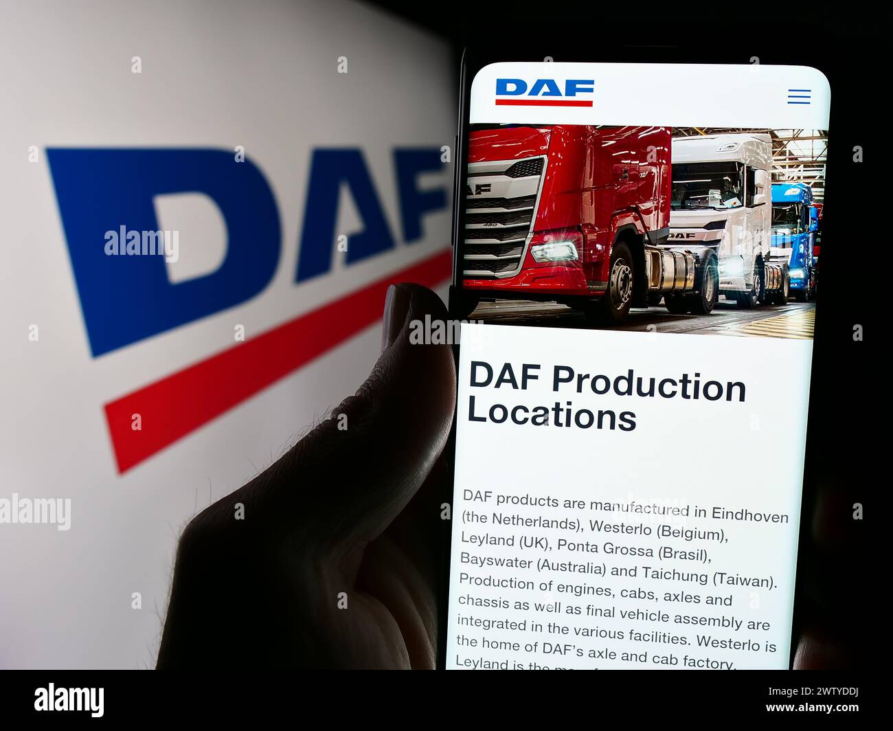 Person holding cellphone with webpage of Dutch truck manufacturing company DAF Trucks NV in ...