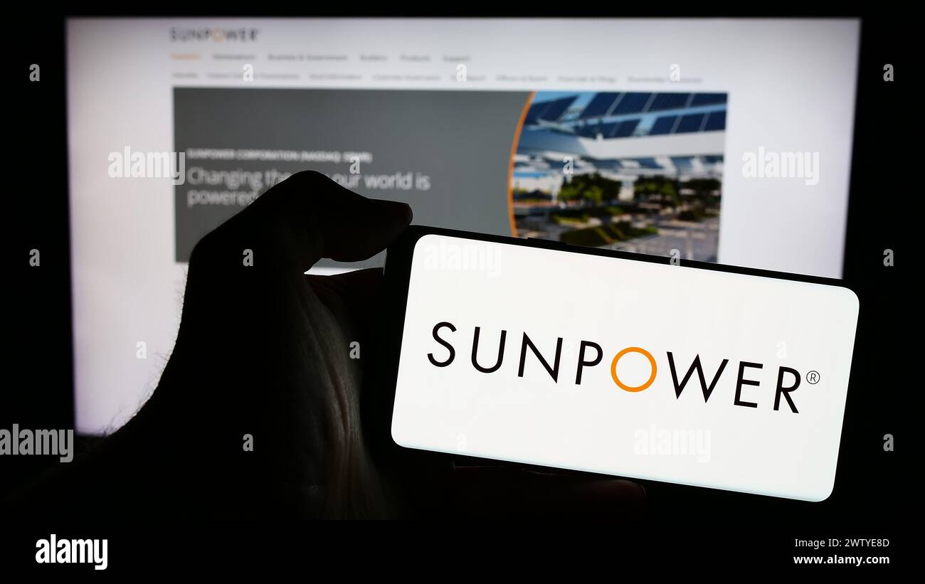 Person holding mobile phone with logo of American photovoltaics company ...