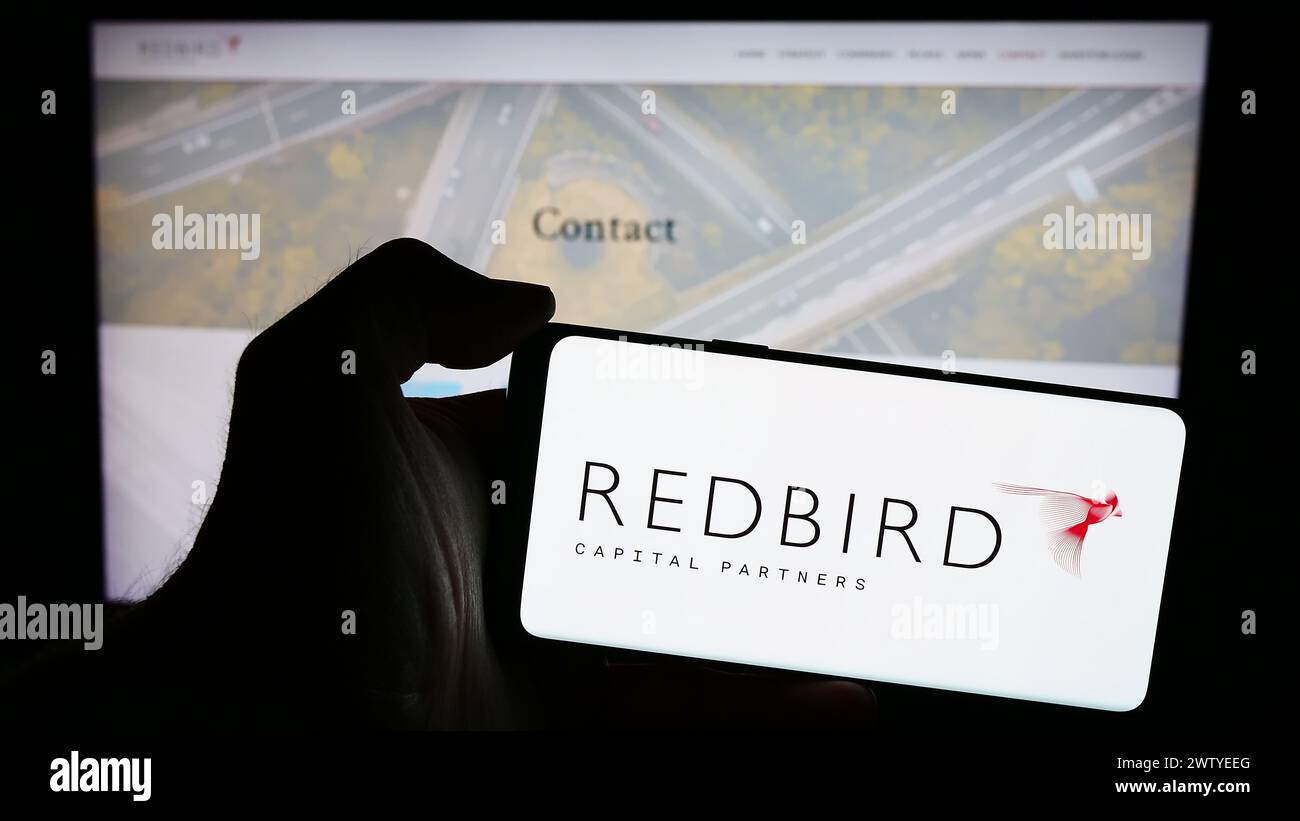 Person holding mobile phone with logo of US investment management ...