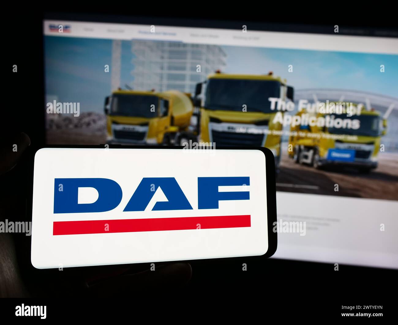 Person holding mobile phone with logo of Dutch truck manufacturing ...