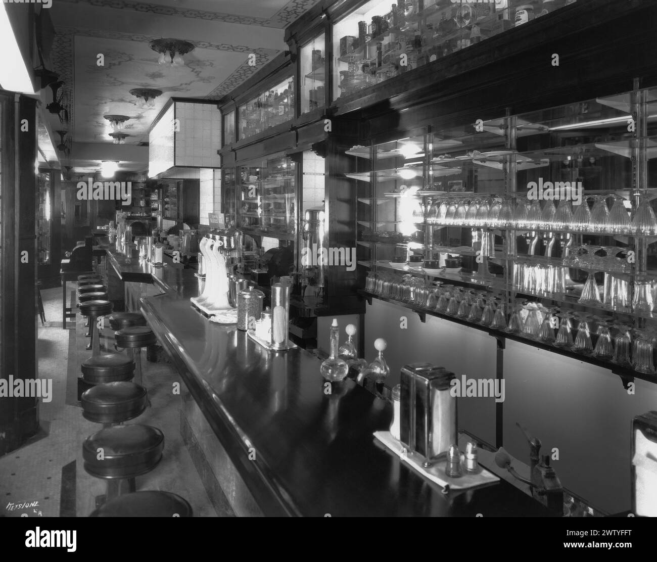 Interior view of an empty long counter with stools inside a coffee shop ...