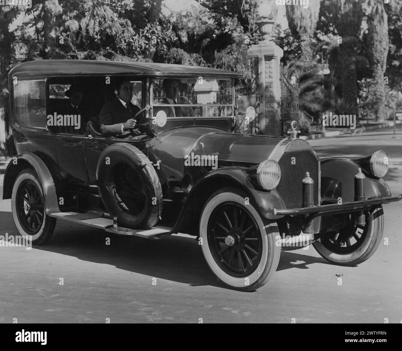 Three men pictured in a 1930s 'Pierce Arrow' automobile with right hand ...