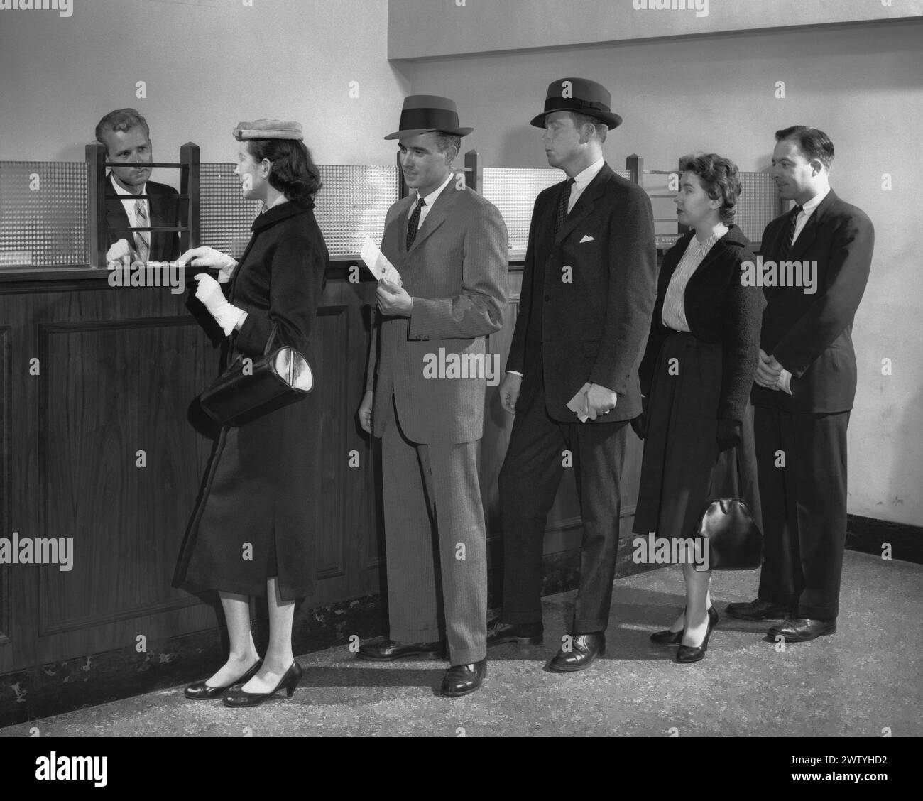 A line of people at the bank teller's window await their turn Stock ...