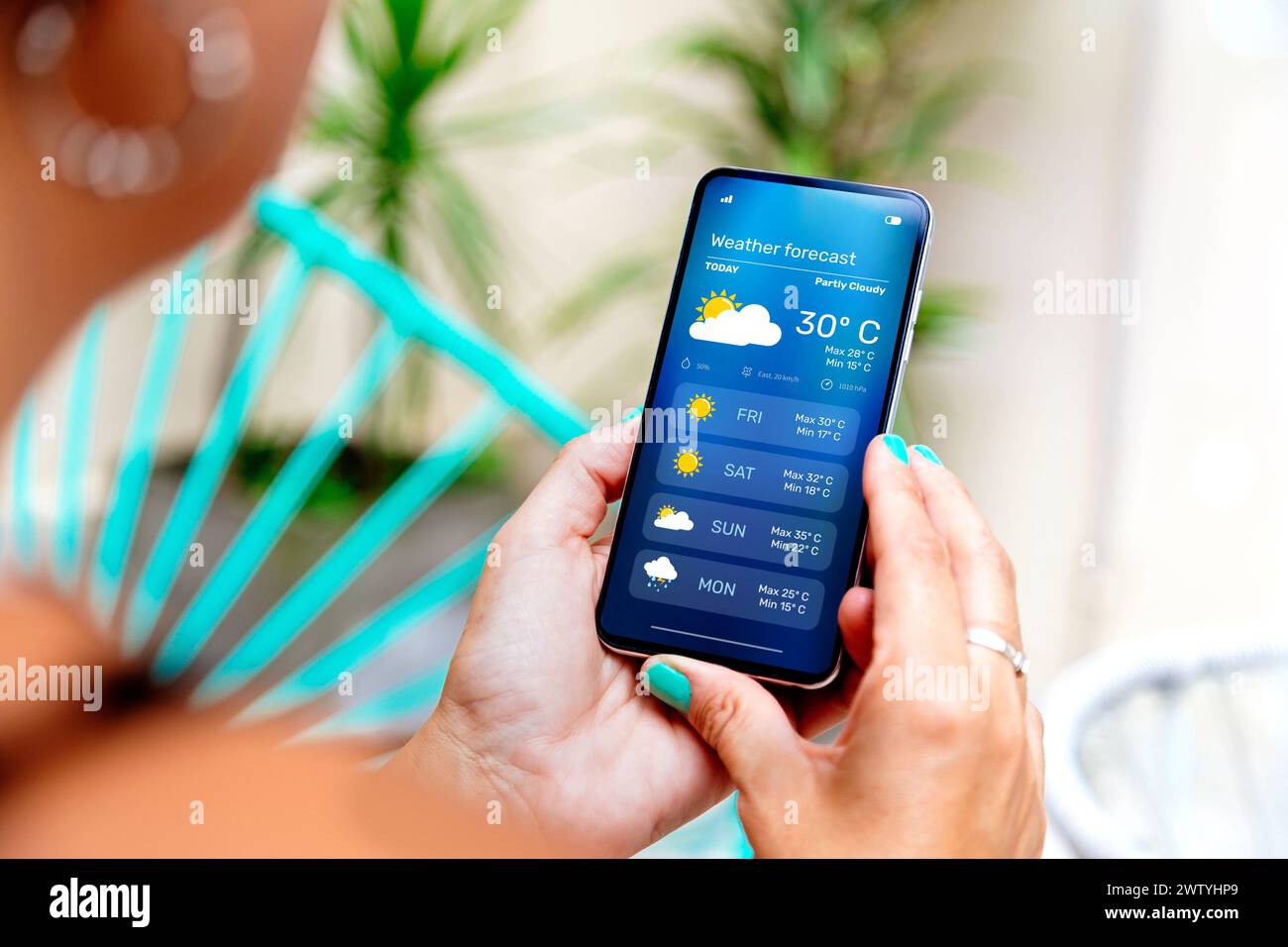Woman outdoors checking the weather forecast on an app on her mobile phone Stock Photo - Alamy