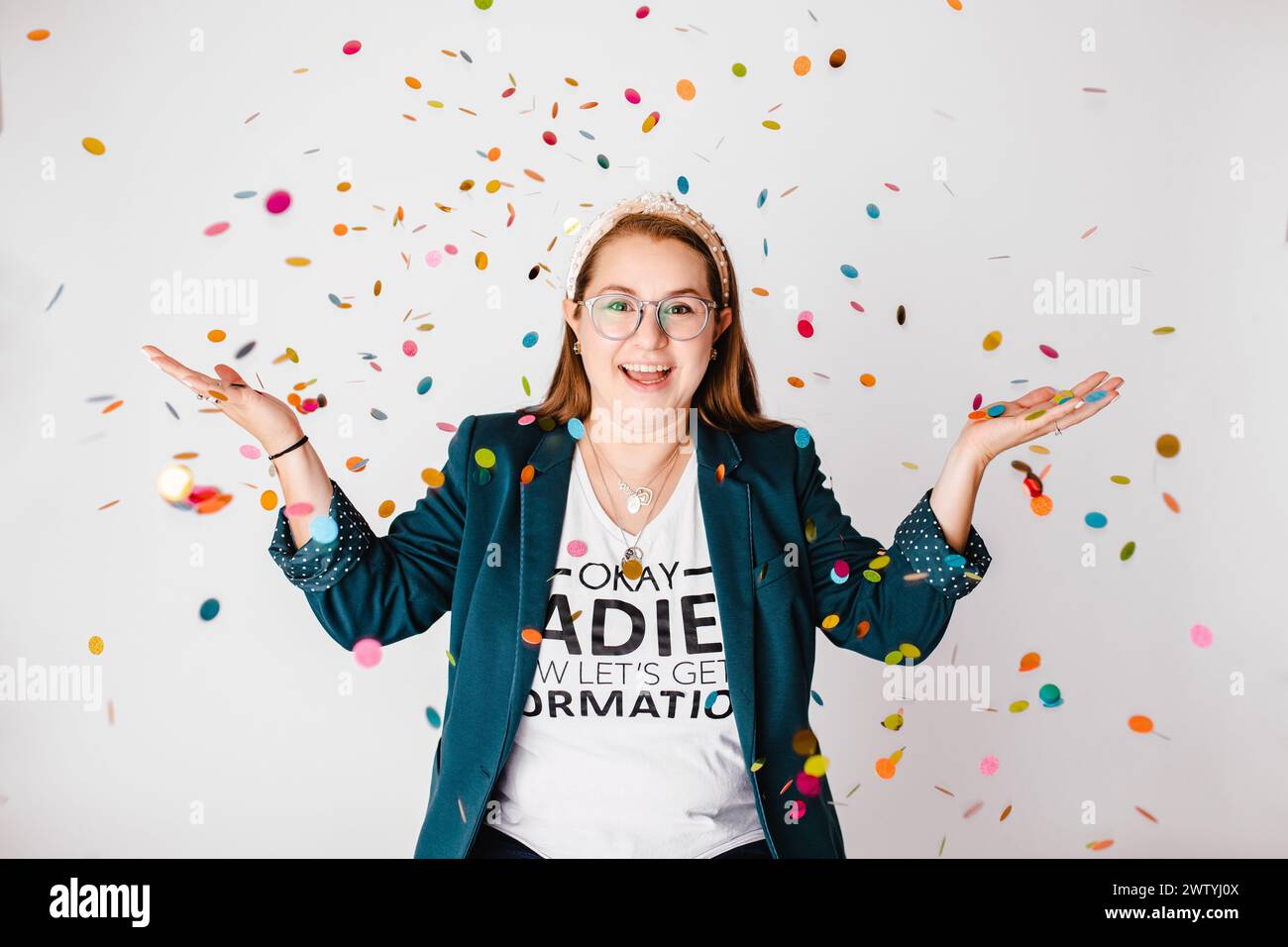 Woman celebrating with confetti poppers Stock Photo - Alamy