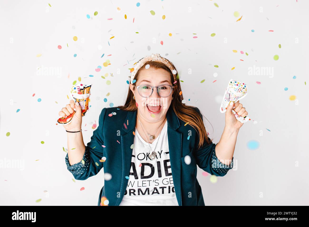 Woman celebrating with confetti poppers Stock Photo - Alamy