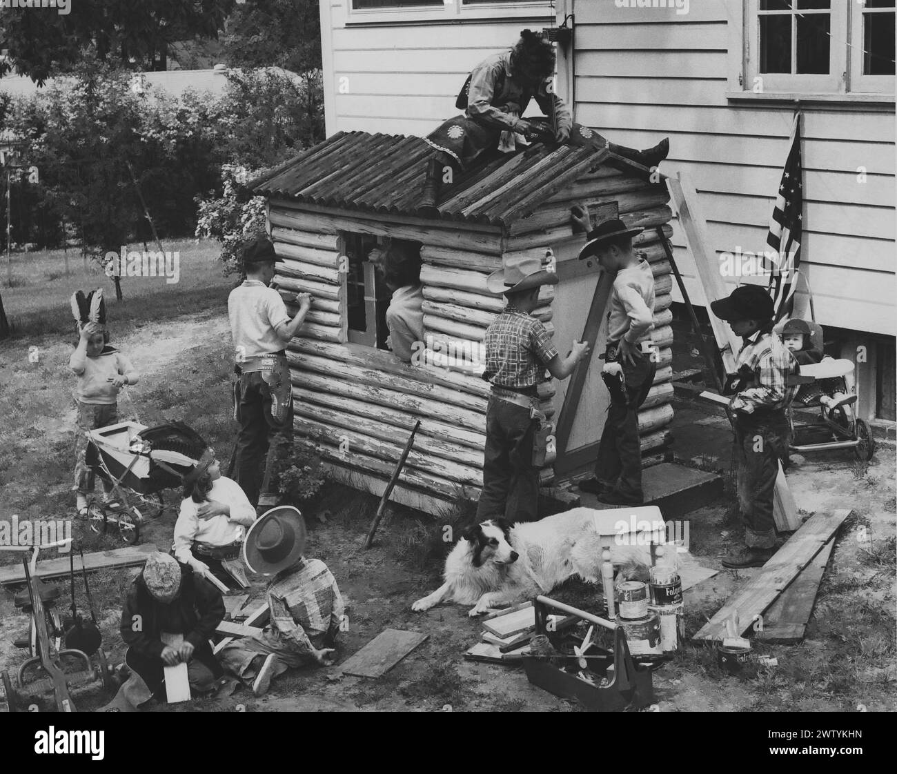 Boys in cowboy hats wearing holsters with toy guns in them building a ...