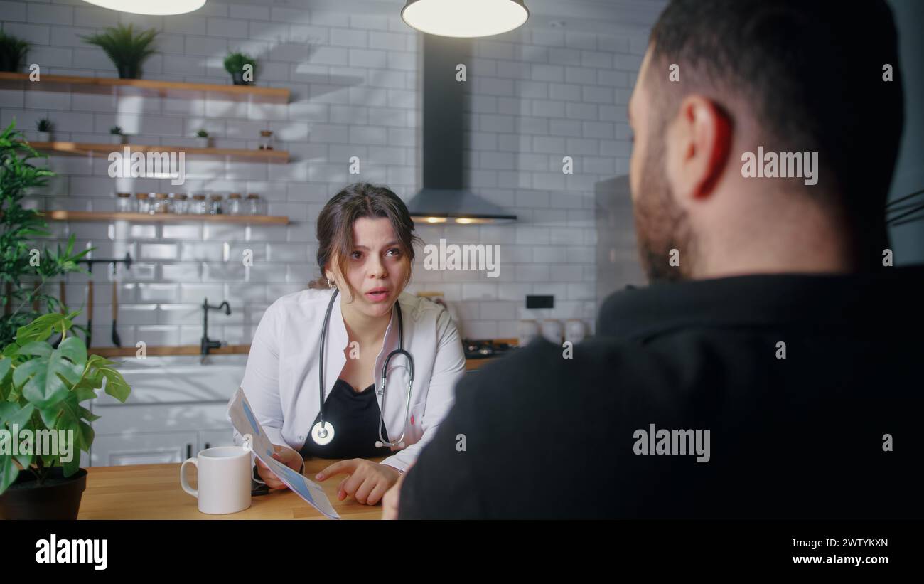 Female doctor in white uniform with stethoscope talks examine patient ...