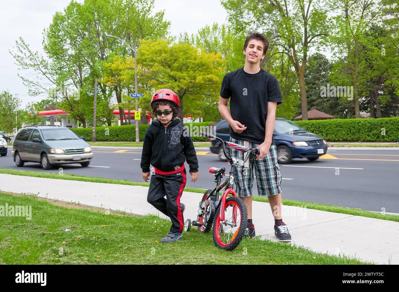 Male teen teaching his brother sibling child how to ride bicycle Stock ...