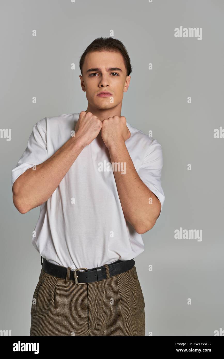 good looking male model in debonair attire posing with fists in front ...