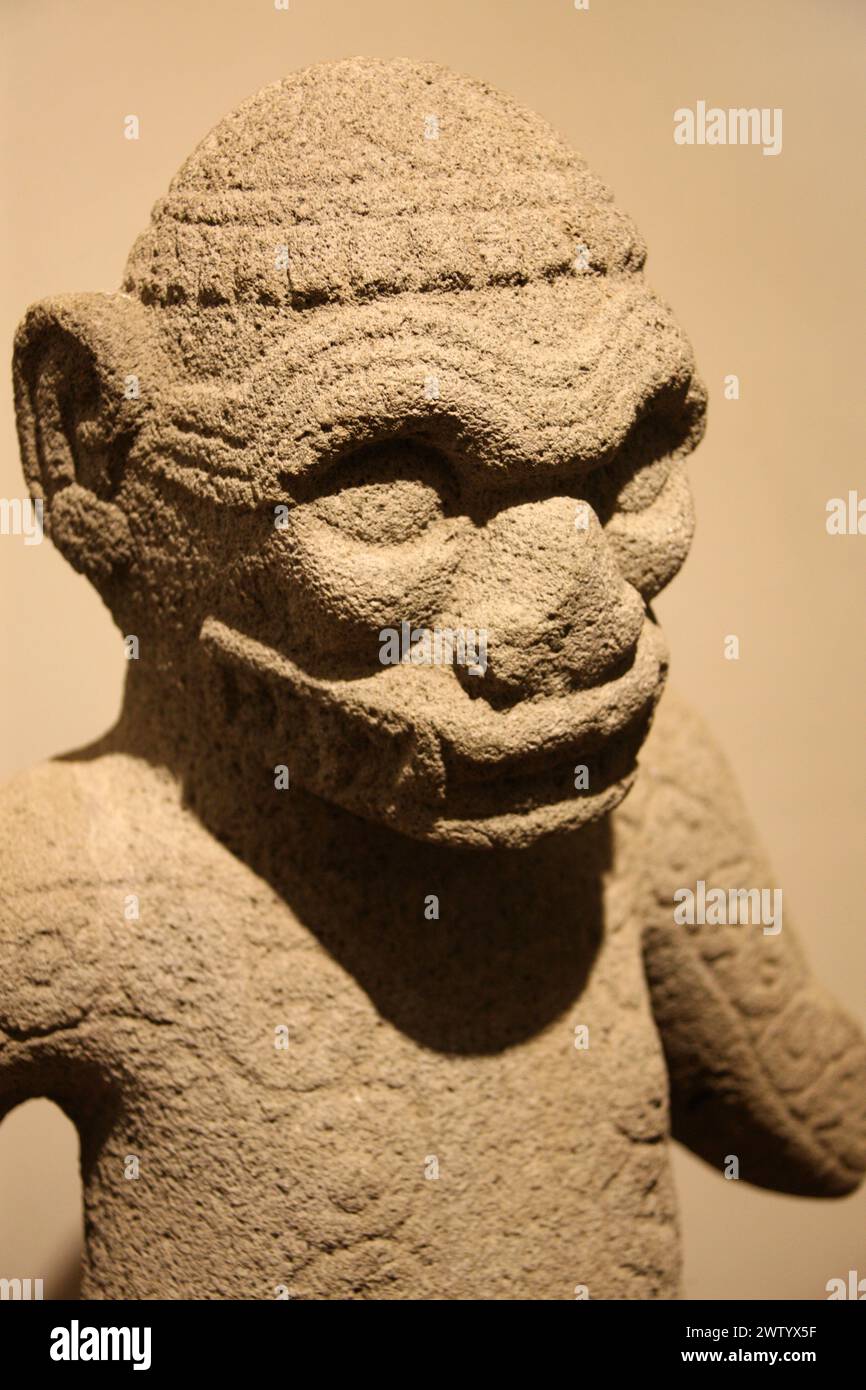 Pre-Columbian stone sculpture of a male figure with an elaborate feline ...