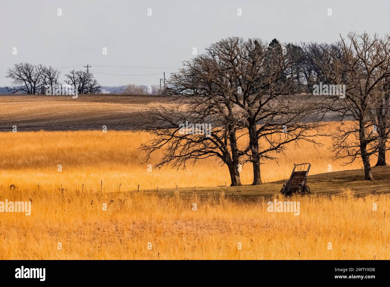 Prairie and trees with old hay loader on private land viewed from Pilot ...