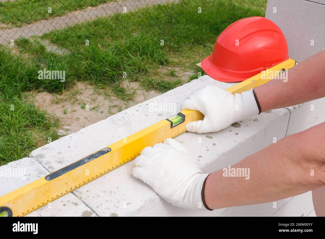 Builder hands with construction level measuring plane level at ...