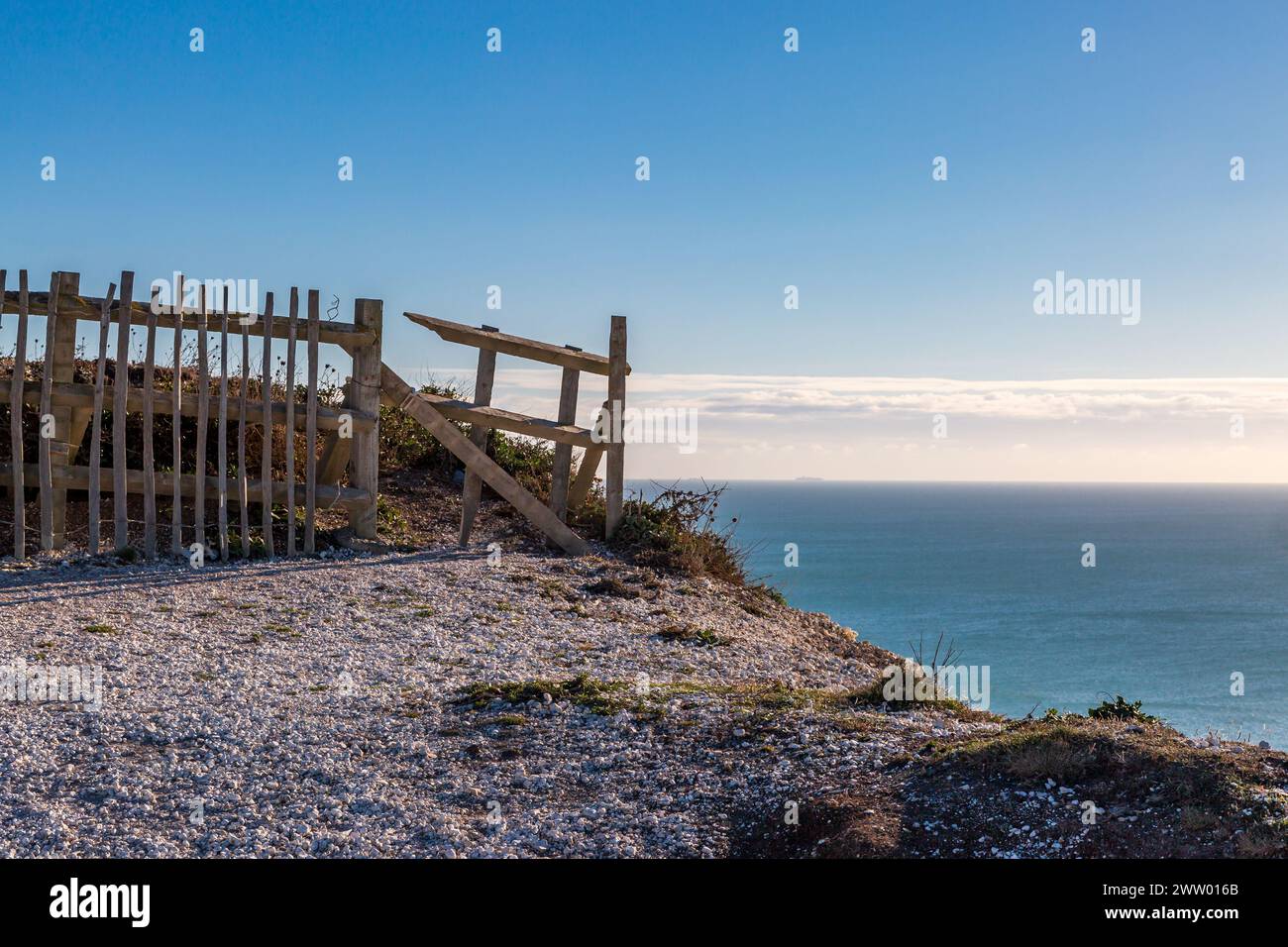 Looking out over the sea from on top of a cliff, with a blue sky ...