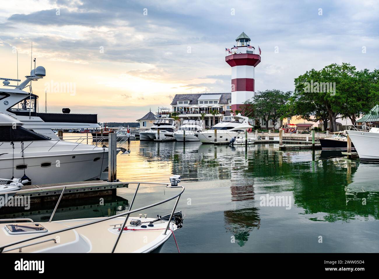 Boats moored in a harbor with a lighthouse in the distance Stock Photo ...