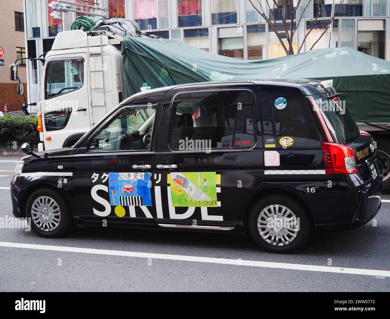 TOKYO, JAPAN - March 19, 2024: A taxi in traffic in Tokyo's Omotesando ...