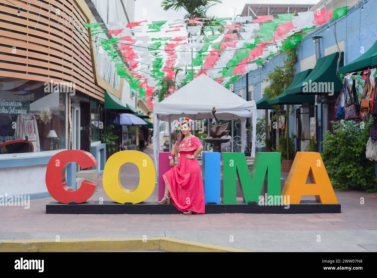 Mexican woman wearing traditional costume next to the giant letters of ...