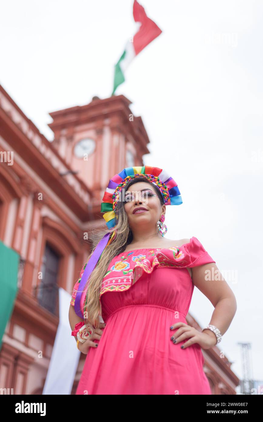 Mexican woman wearing traditional dress. Street decorated with colors ...