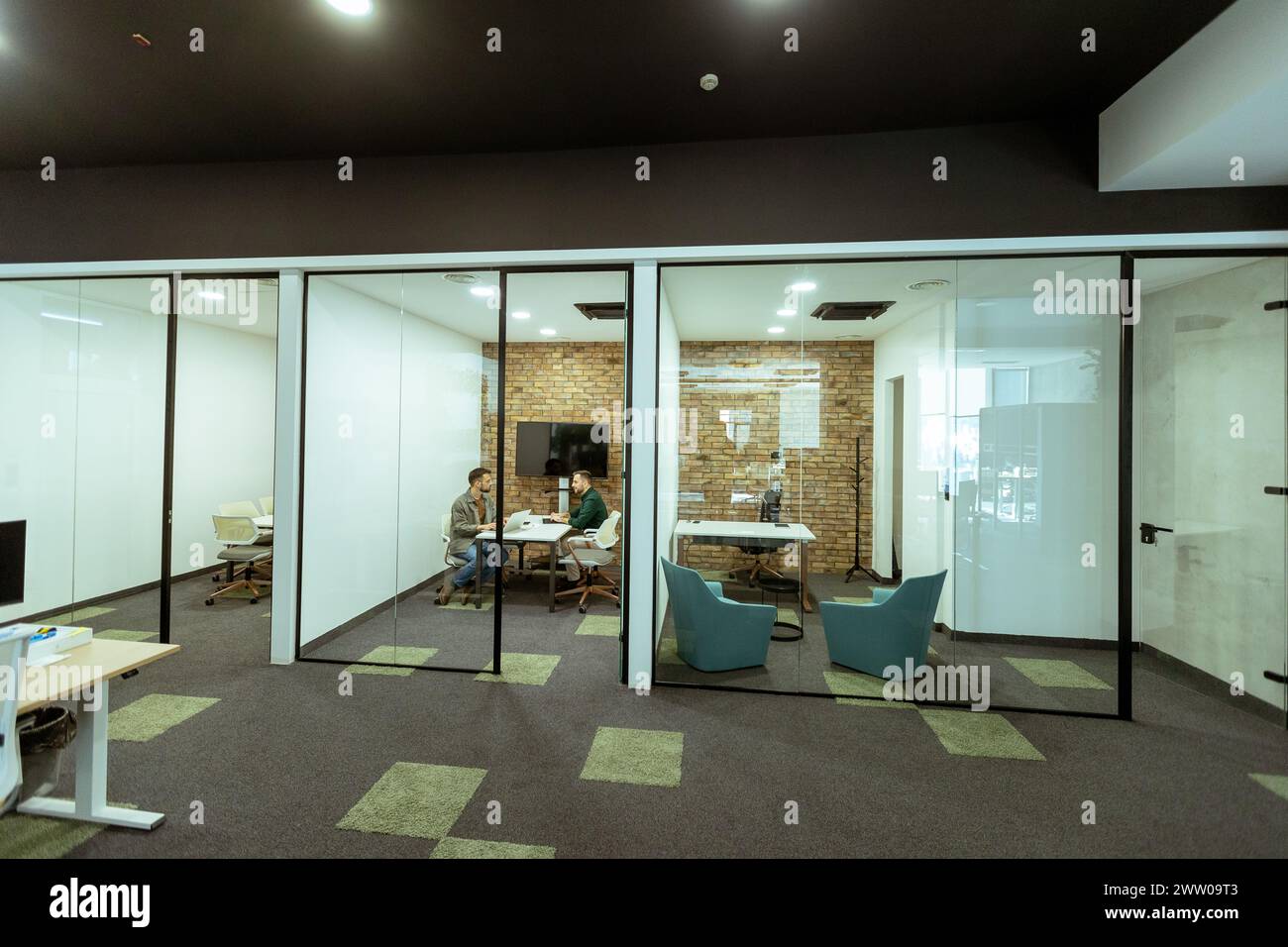 Two professionals engage in a conversation while seated comfortably in ...