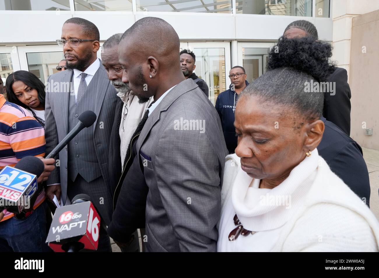 Melvin Jenkins, second from left, speaks to reporters while standing ...