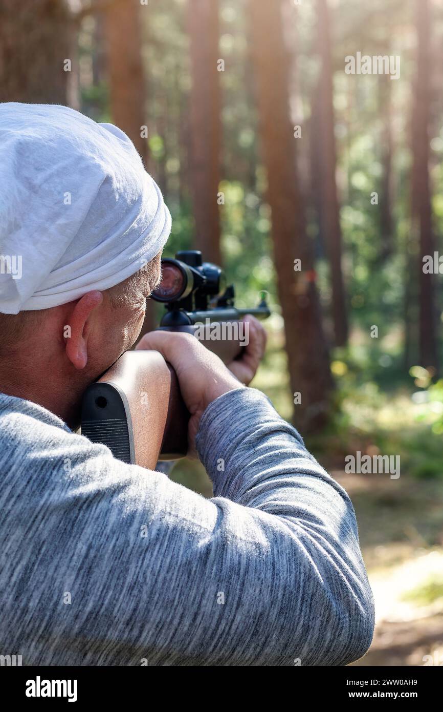 The man aimed into the distance with the help of an optical sight. Back ...