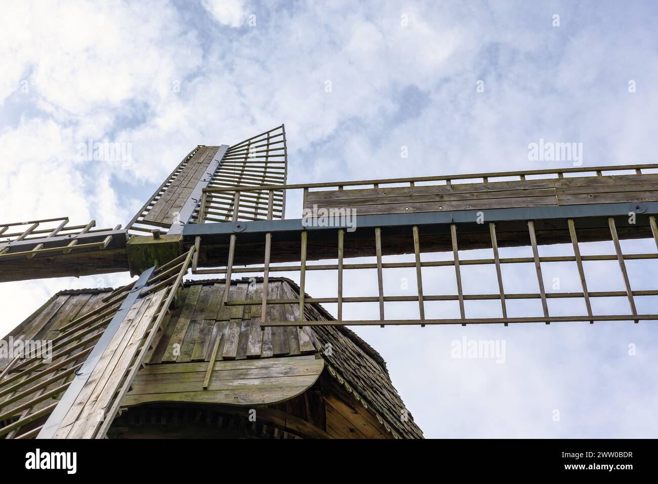 Old wooden wind mill on blue sky background. Old Windmill from below ...