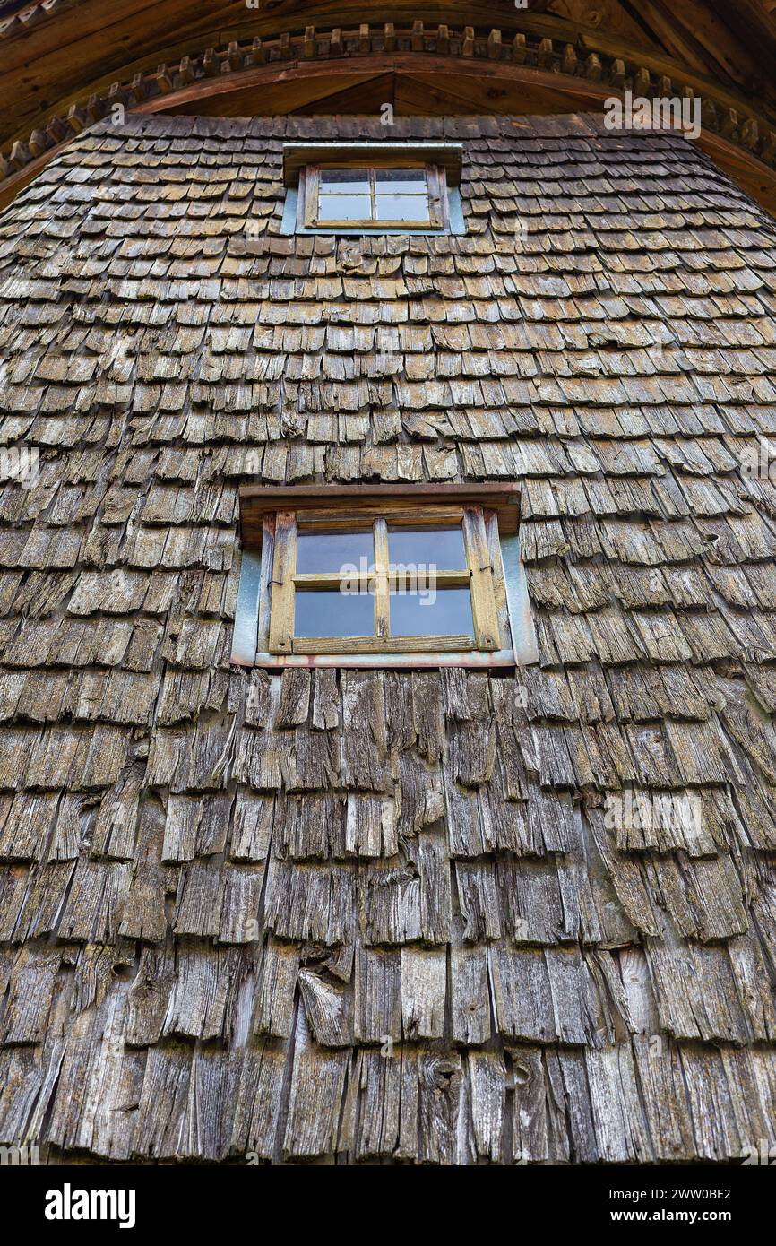 The wall of the ancient mill is covered with wooden chips and two small ...