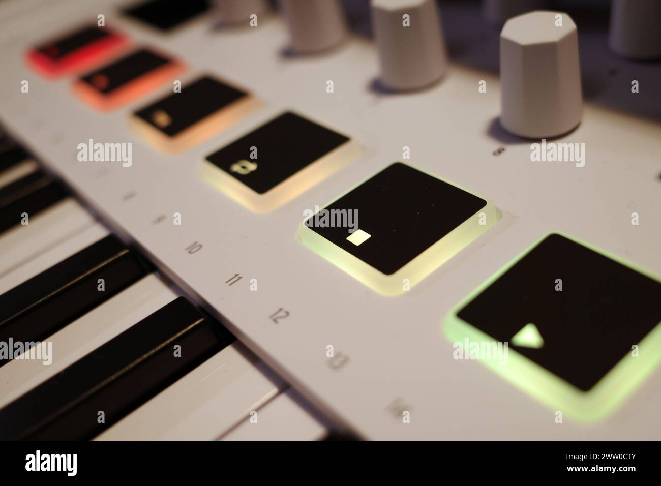 Detail of a modern mini synthesizer with red, orange and yellow glowing ...